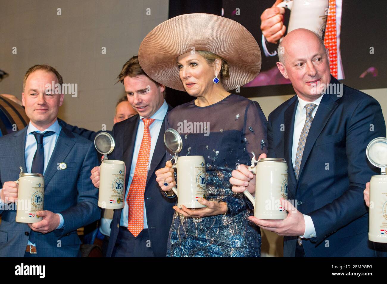 Queen Maxima drinks beer from a giant beer mug during the start of the ...