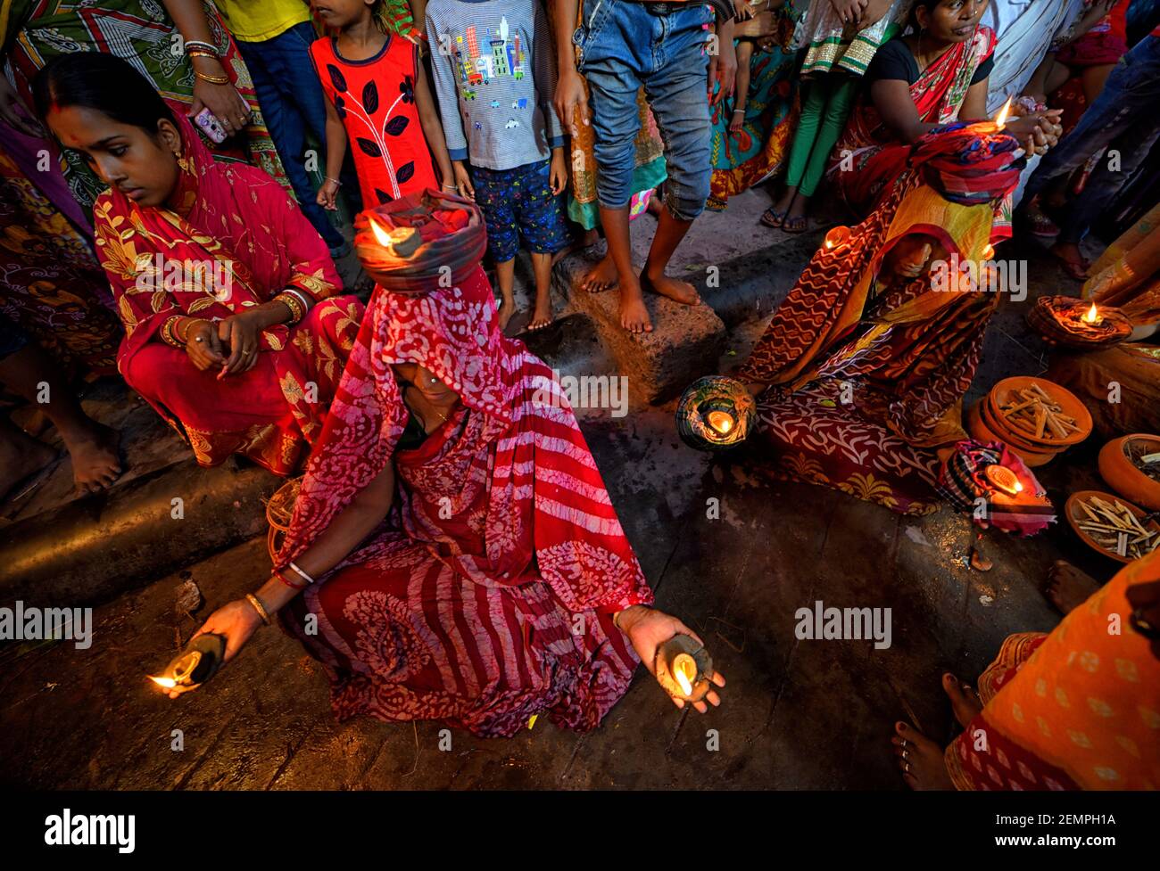Hindu women are seen seated with burning fire pots on their head as a ...