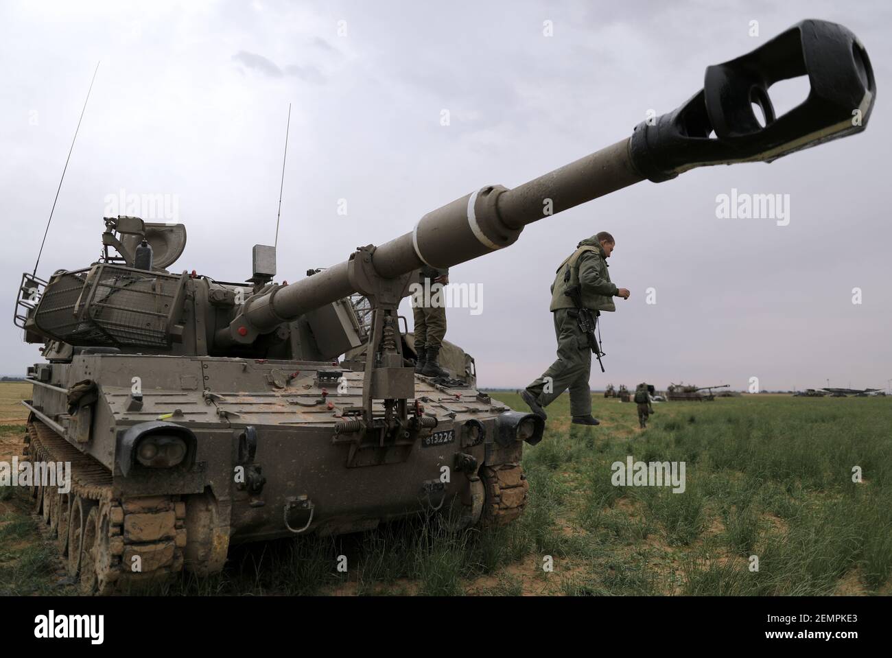 Israeli soldiers stand on and around a mobile cannon near the border ...