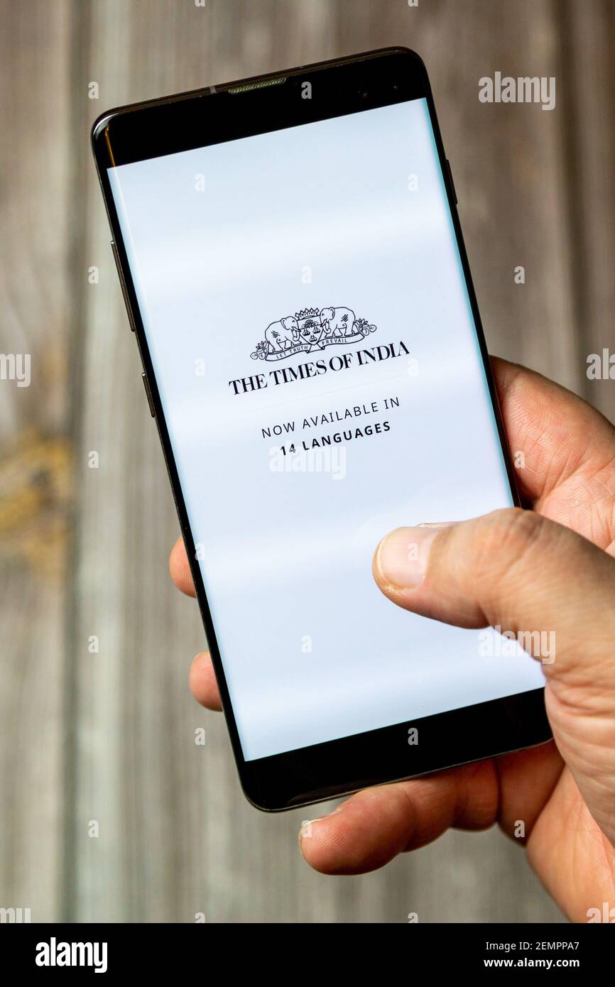 A mobile phone or cell phone being held by a hand with the times of ...