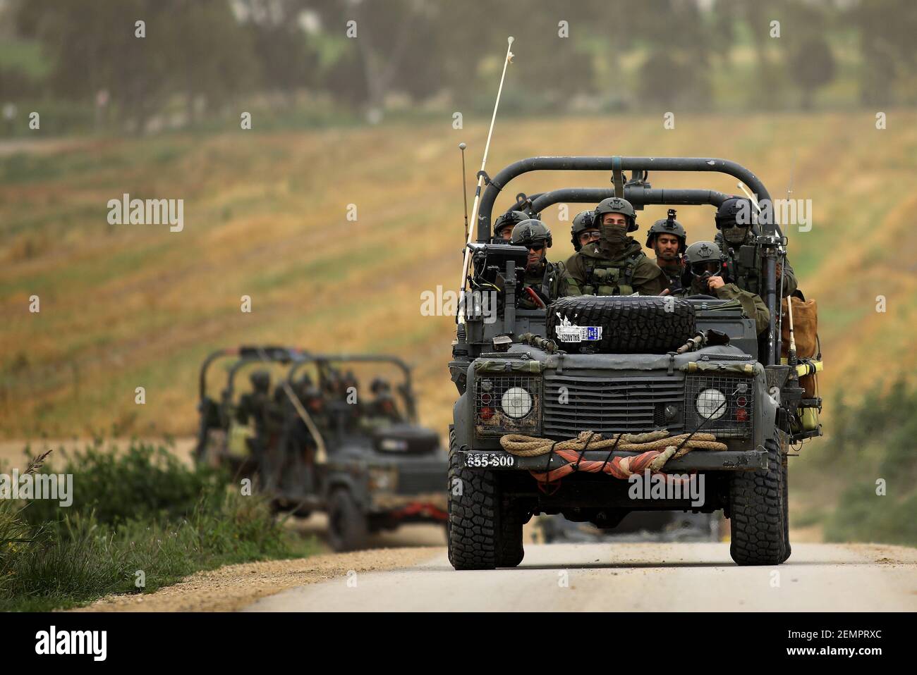 Israeli soldiers drive military vehicles near the border with Gaza, in ...