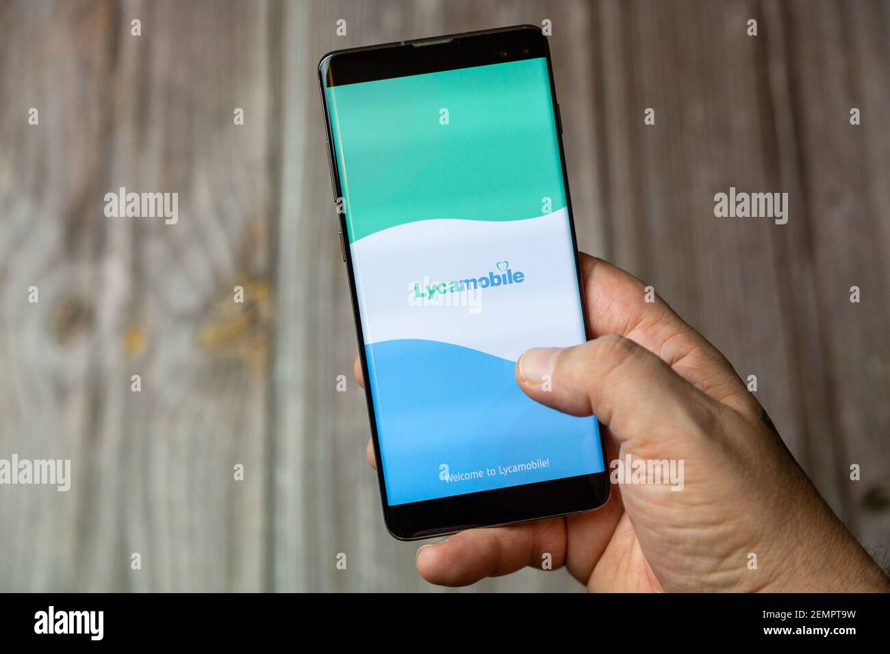 A mobile phone or cell phone being held by a hand with the Lyca mobile ...