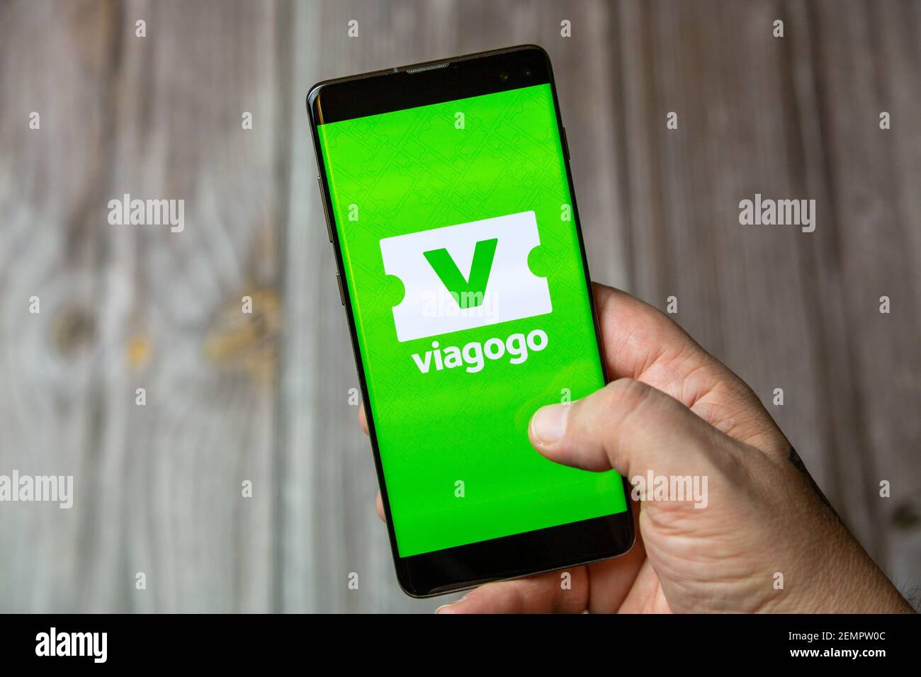 A mobile phone or cell phone being held by a hand with the Viagogo app ...
