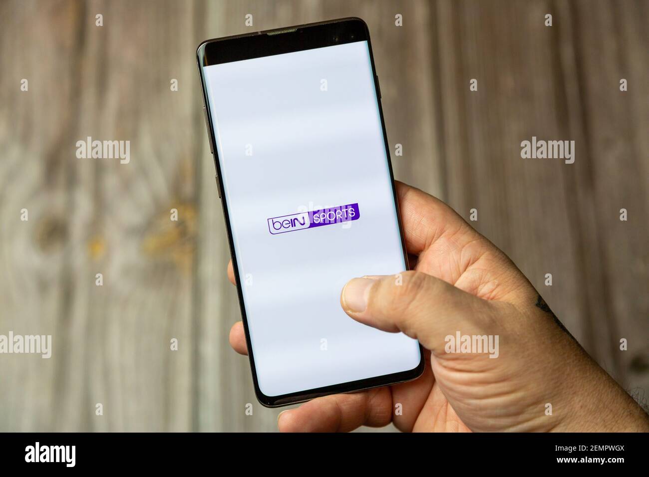 A mobile phone or cell phone being held by a hand with the Bein sports ...