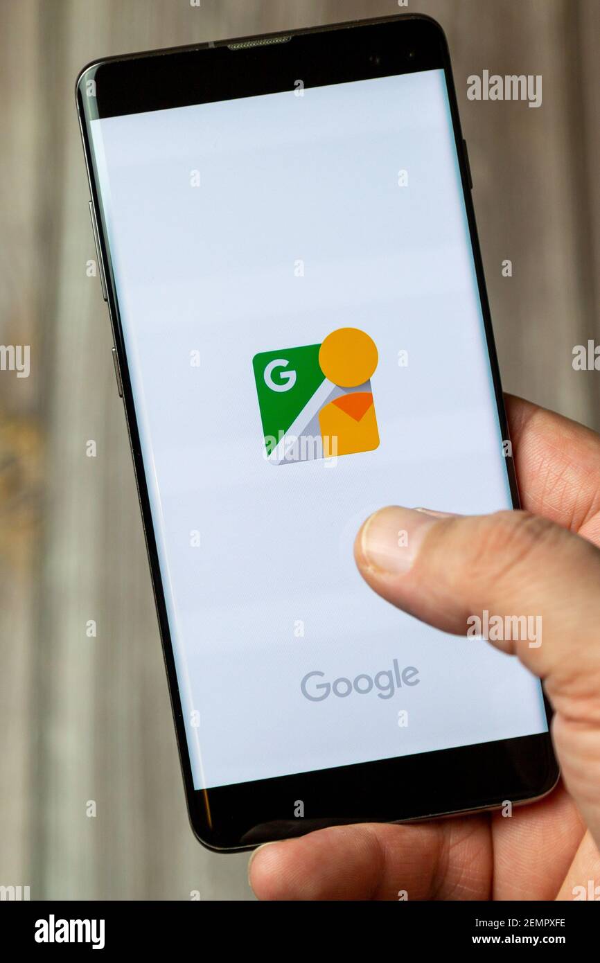 A mobile phone or cell phone being held by a hand with the Google ...