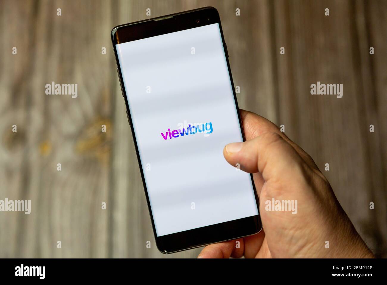 A mobile phone or cell phone being held by a hand with the Viewbug app ...