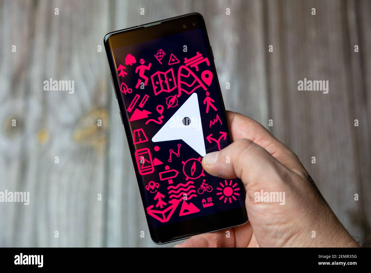 A mobile phone or cell phone being held by a hand with the OS Maps app ...