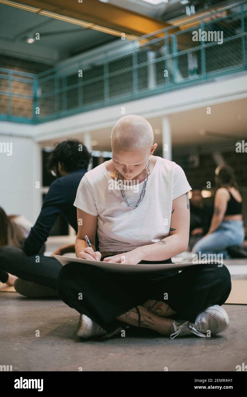 Bald female protestor making signboard in building Stock Photo - Alamy