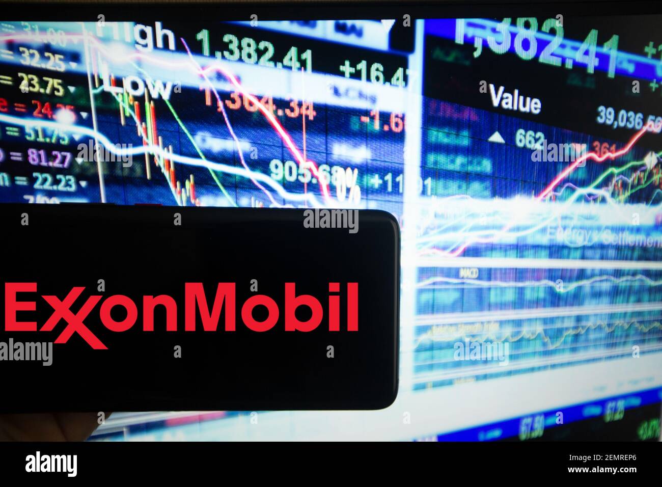 The logo of Exxon Mobil is seen on the screen of a smartphone next to ...