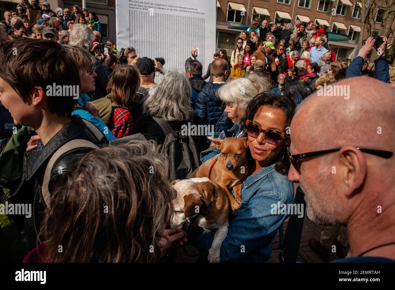 A group of people are seen gathering in front of the Shell building ...