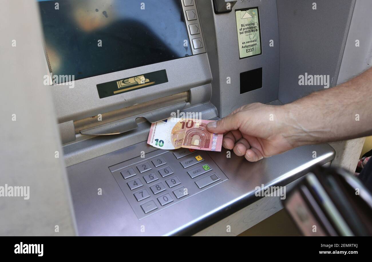 05-04-2019 Delft Withdrawing a ten Euro banknote from an ATM machine ...