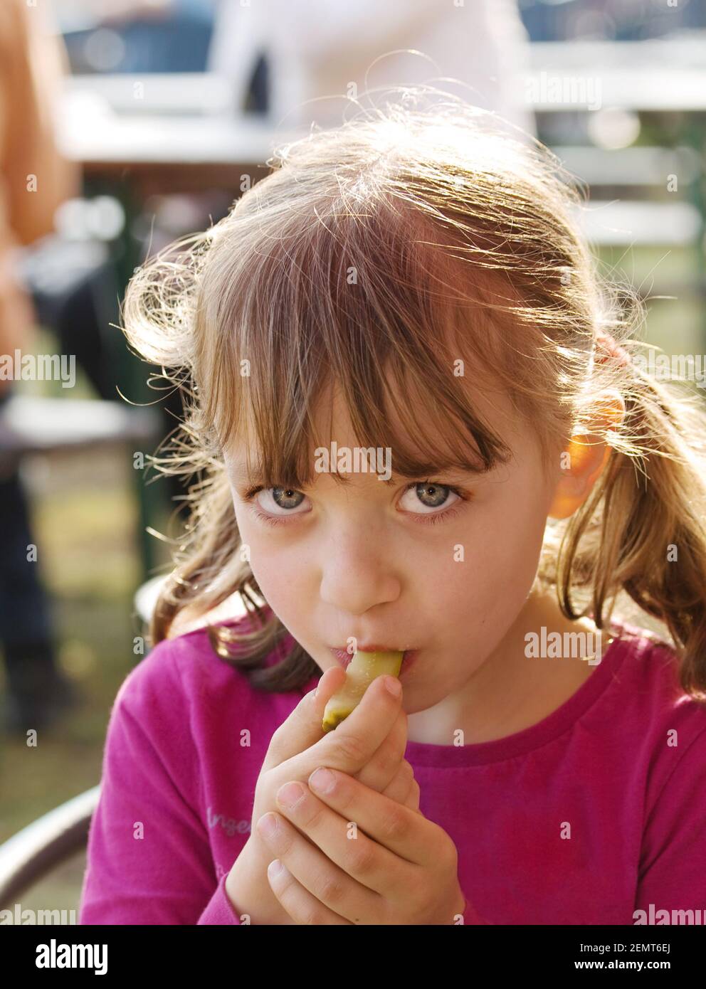 Little girl eating pickle snacks Stock Photo - Alamy