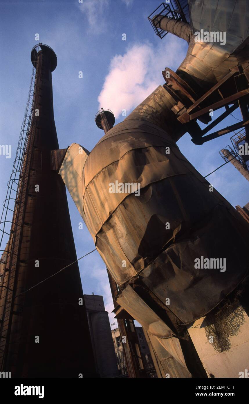 old rusty metal flue pipes against the blue sky. Industrial landscape ...