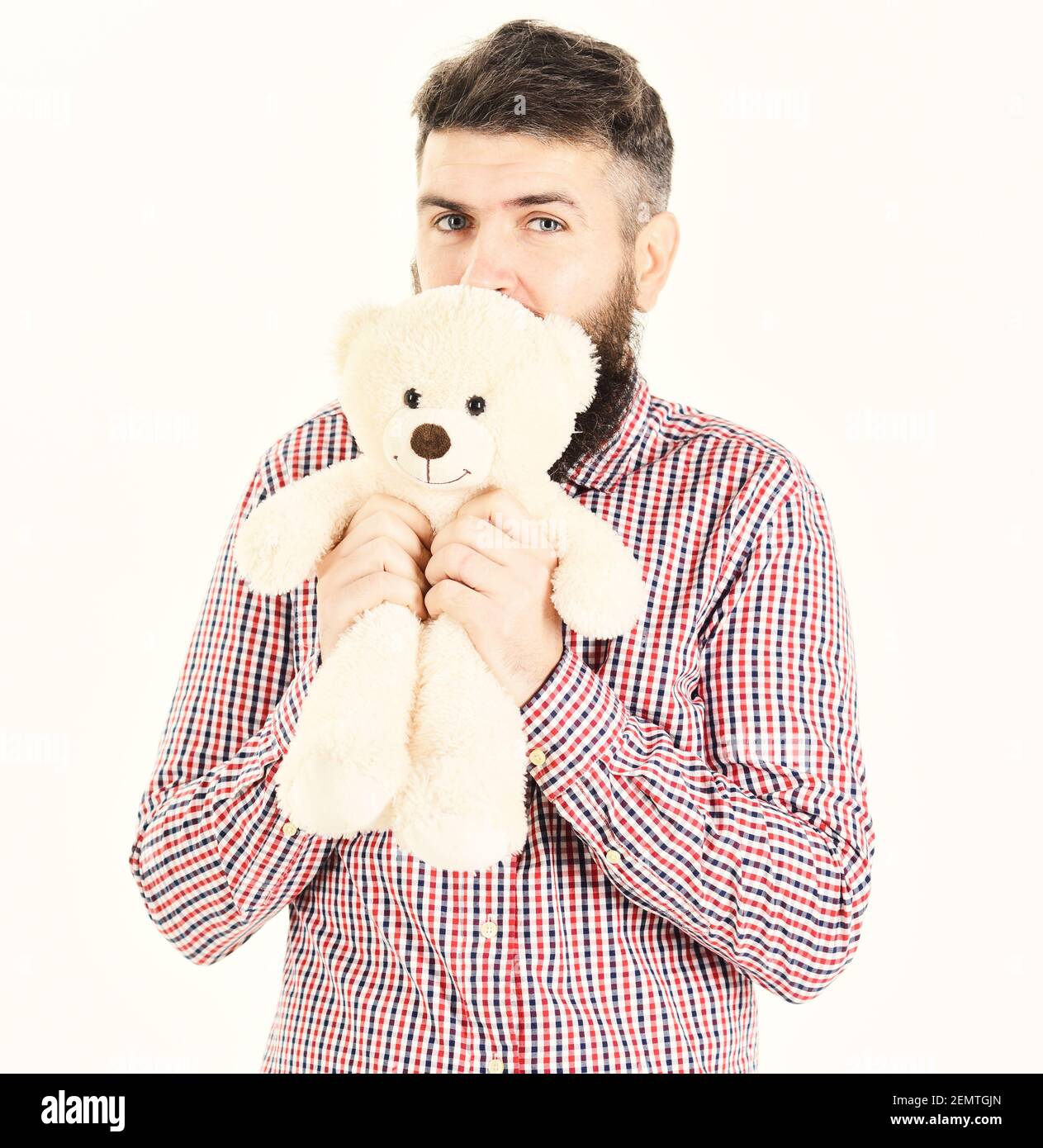 Guy with beard hugs soft toy with tenderness. Hipster cares about teddy ...