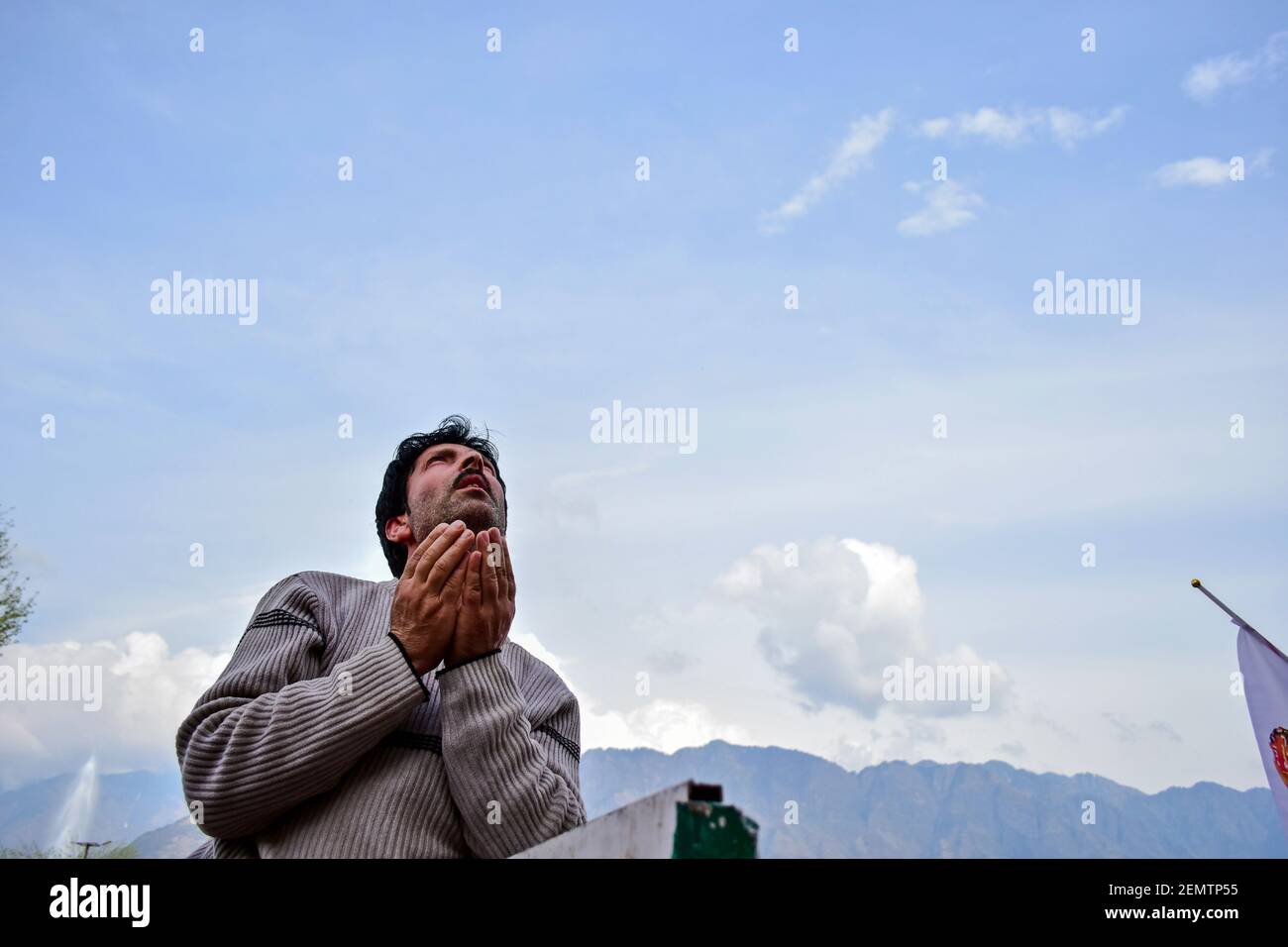 A devotee seen praying upon seeing a relic believed to be hair from the ...