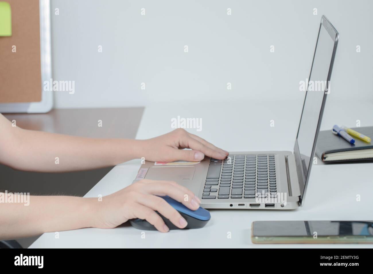 Employee working at grey laptop in the office Stock Photo - Alamy