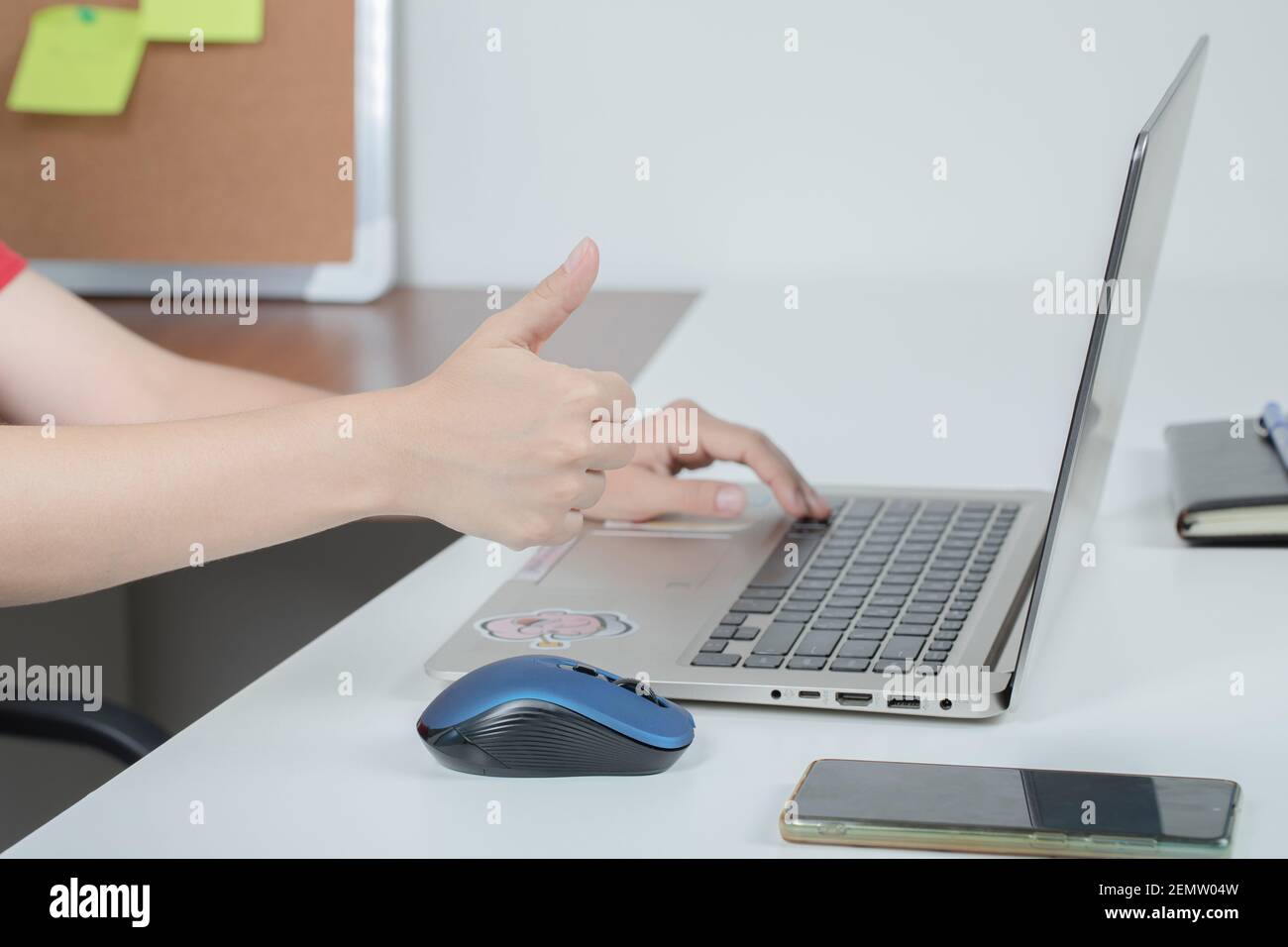 Employee working at grey laptop in the office Stock Photo - Alamy