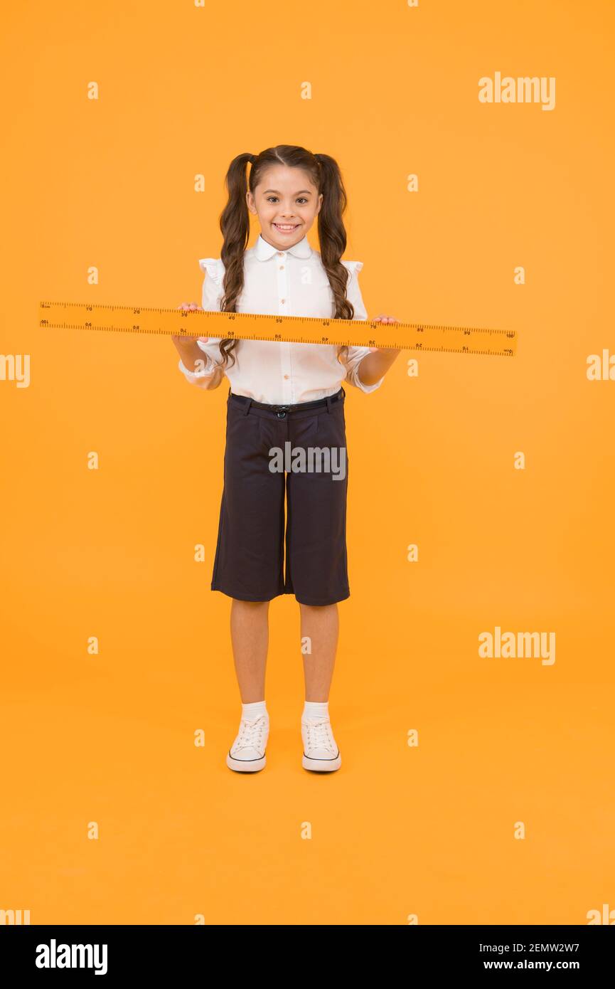 Tell me about distance. Kid school uniform hold ruler. Pupil cute girl ...