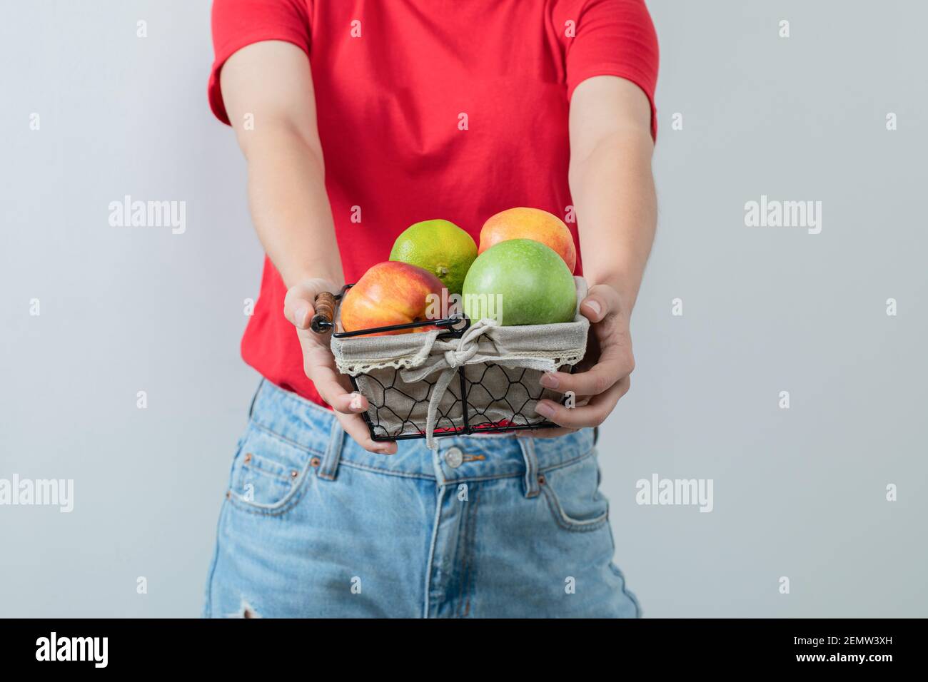 Young girl offering a fruit basket in the hand Stock Photo - Alamy