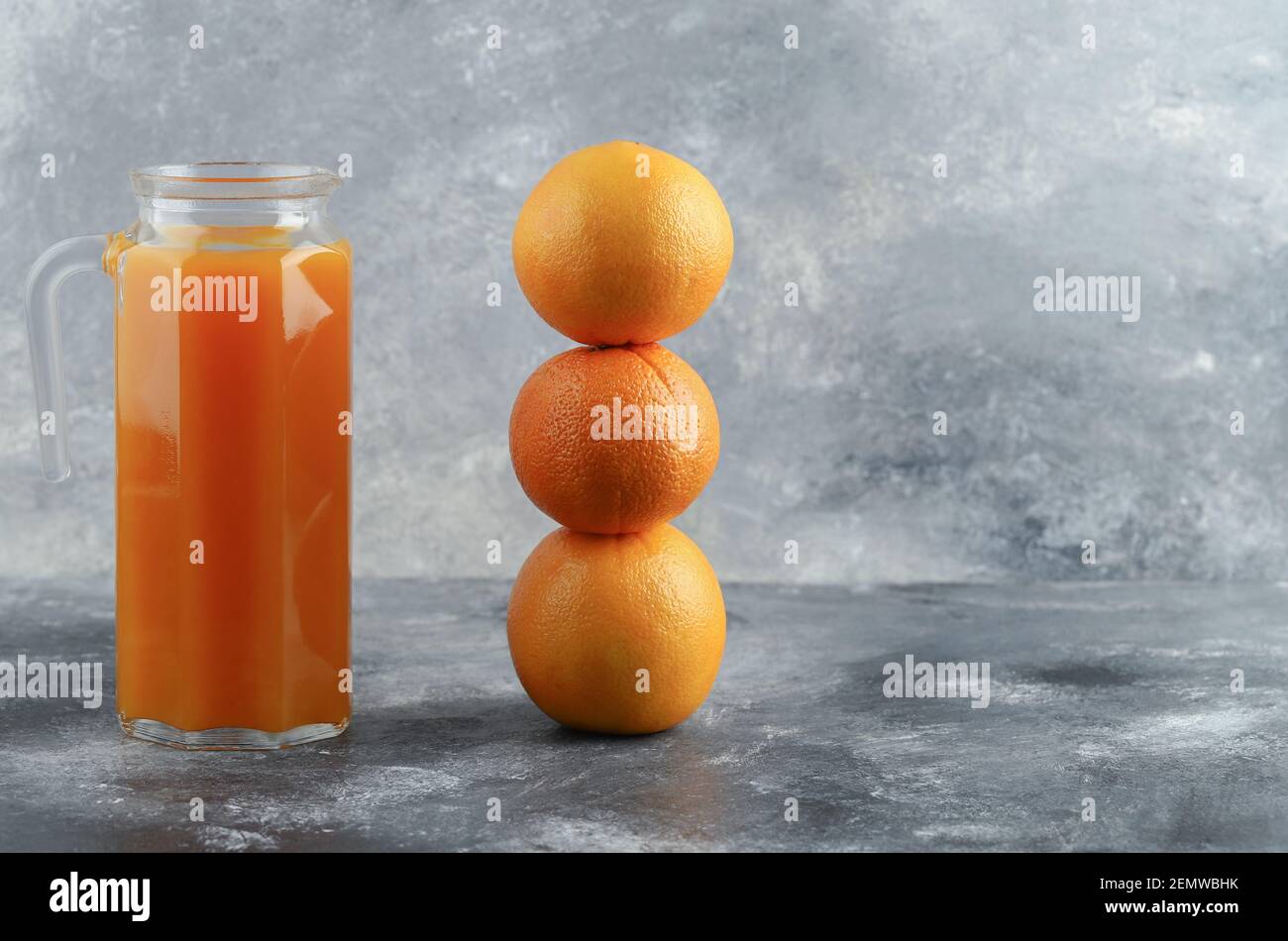 Jug of juice and oranges on marble background Stock Photo - Alamy