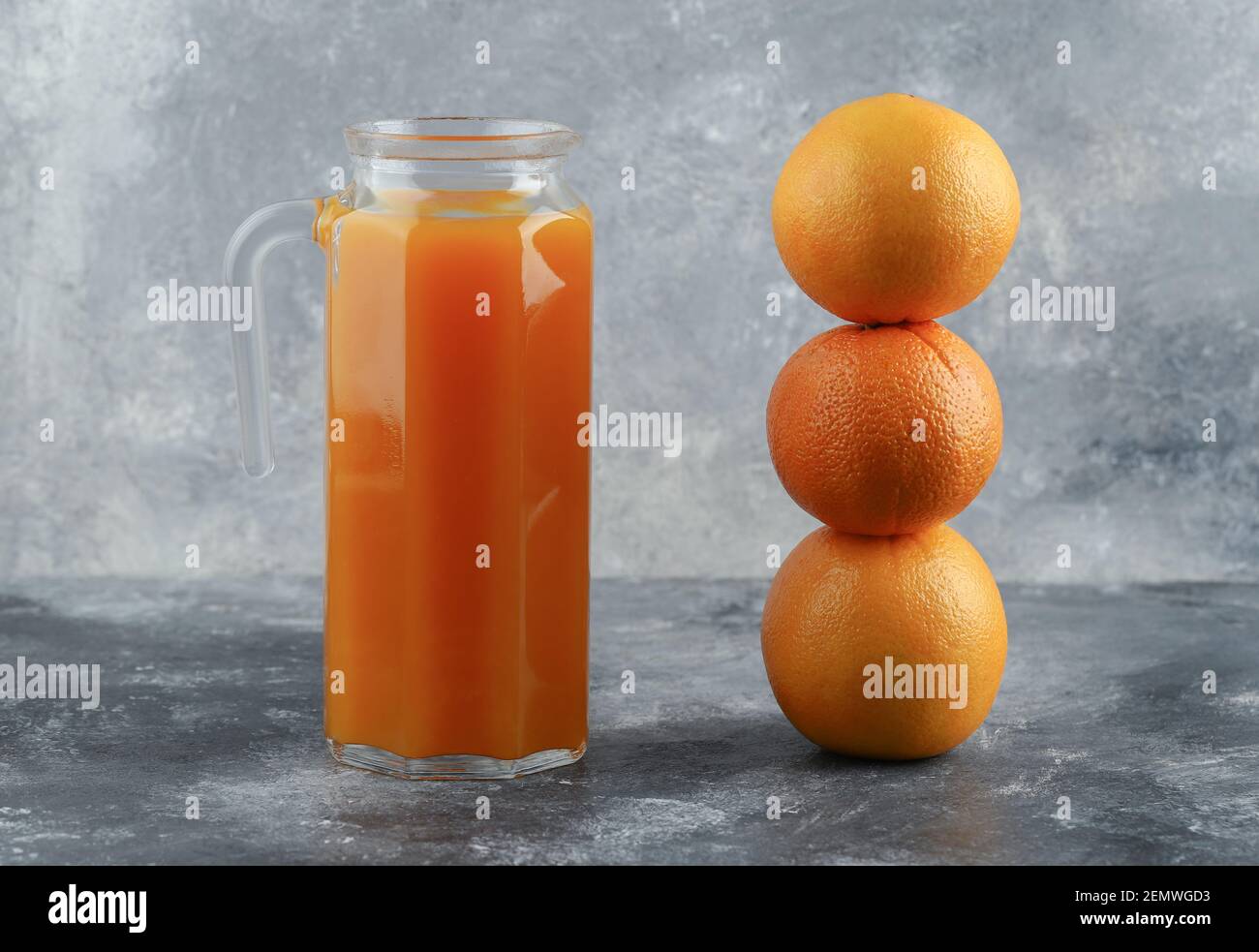 Jug of juice and oranges on marble background Stock Photo - Alamy