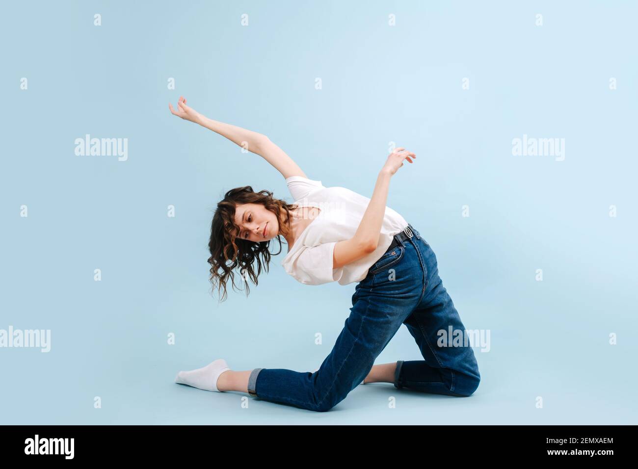 Impressive contemporary dancer poses in front of blue studio background ...
