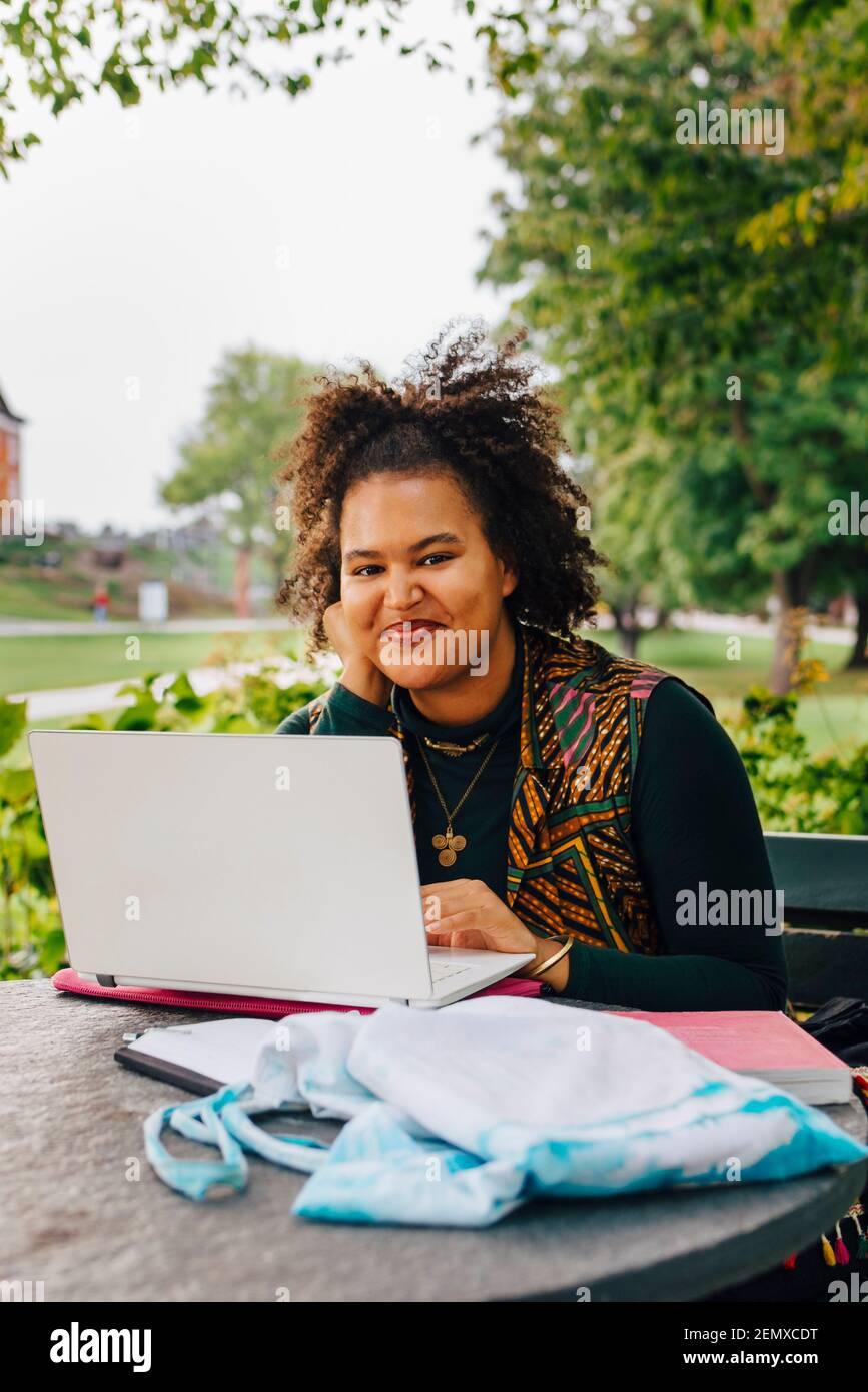 Smiling female student with laptop in college campus Stock Photo - Alamy