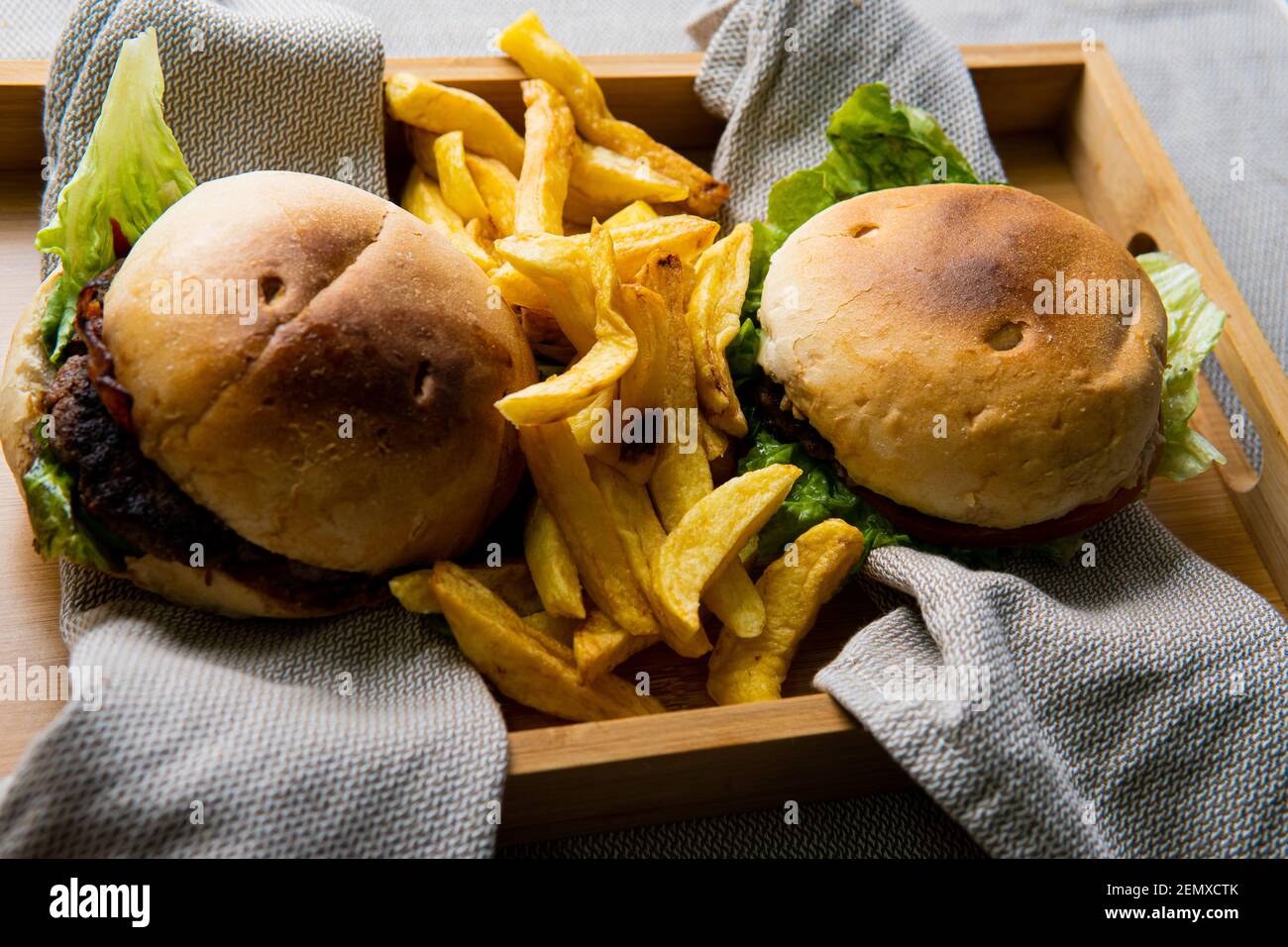 Organic beef burgers with French fries on cloth napkins. fast food ...