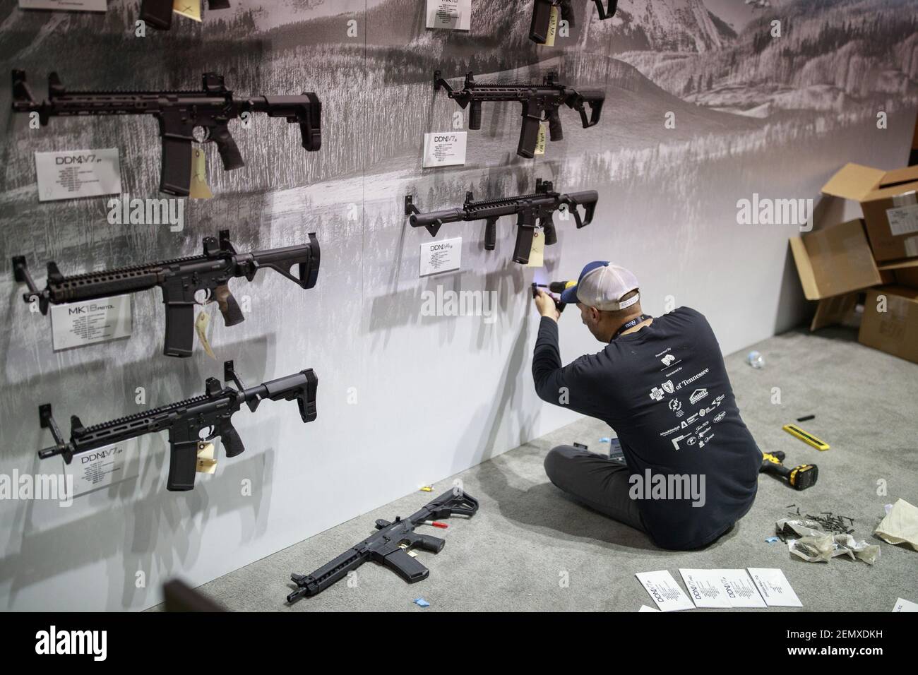 A worker helps prepare the Daniel Defense booth. Vendors prepare booths ...