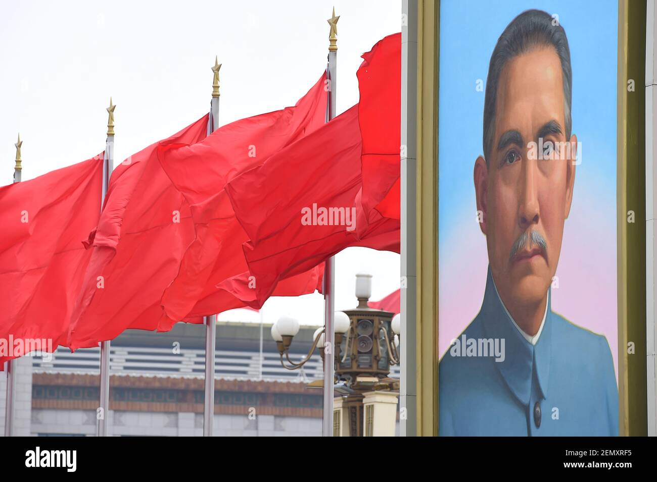 Red flags flutter beside a huge portrait of Chinese revolutionary ...
