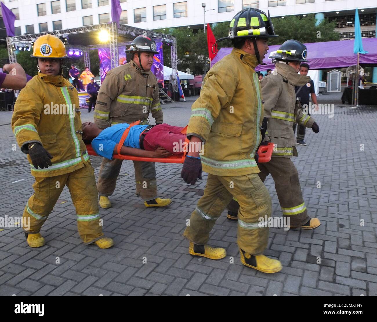 Fire fighters are seen carrying a wounded patient on spine board during ...