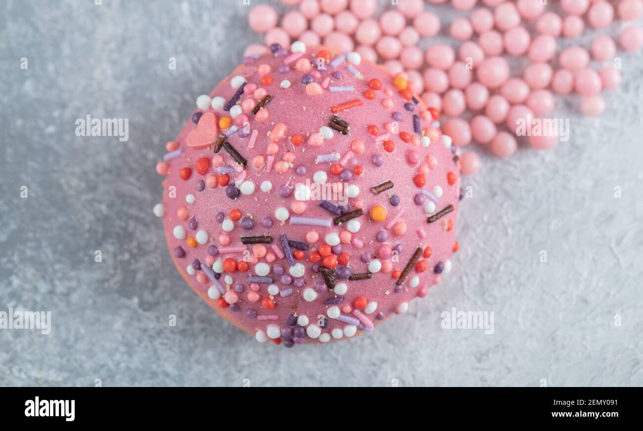 Pink cookie decorated with sprinkles on marble background Stock Photo ...