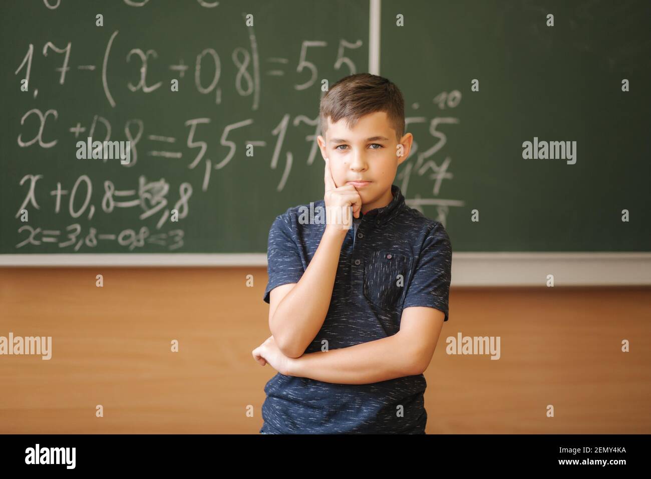 Cute boy stand in the classroom background of blackboard. Education ...