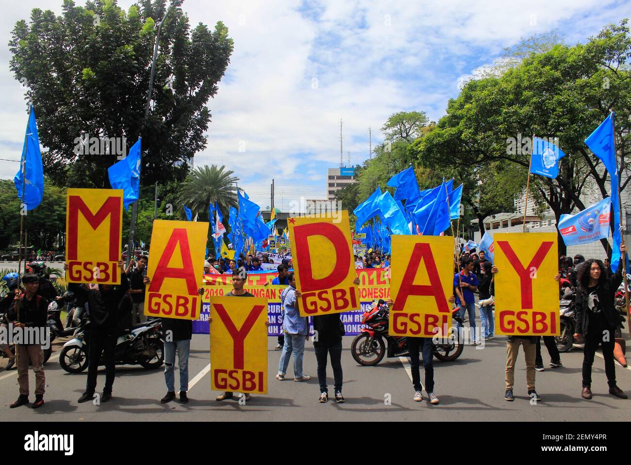 Workers are seen holding placards and flags during the rally. Thousands ...