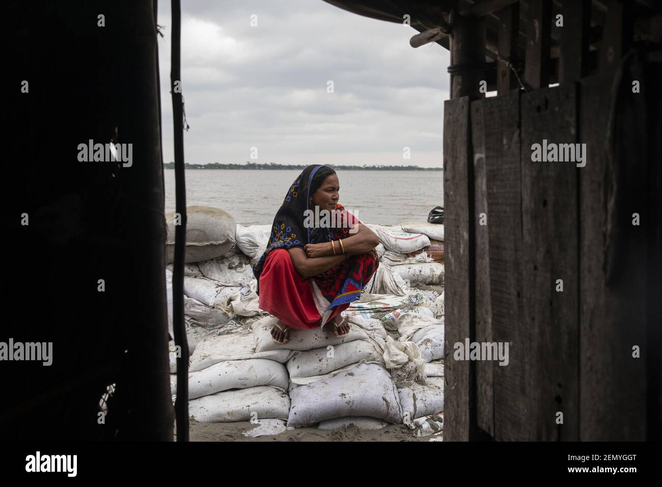 Bangladeshi woman Rubi Begum (40) sits on sandbag embankment that was ...