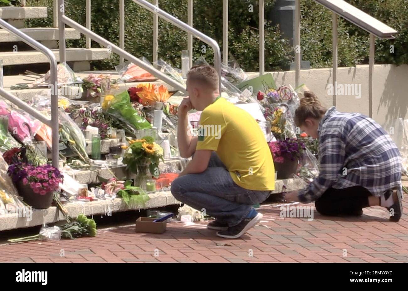 People pay respects at a memorial set up on the steps of the Kennedy ...