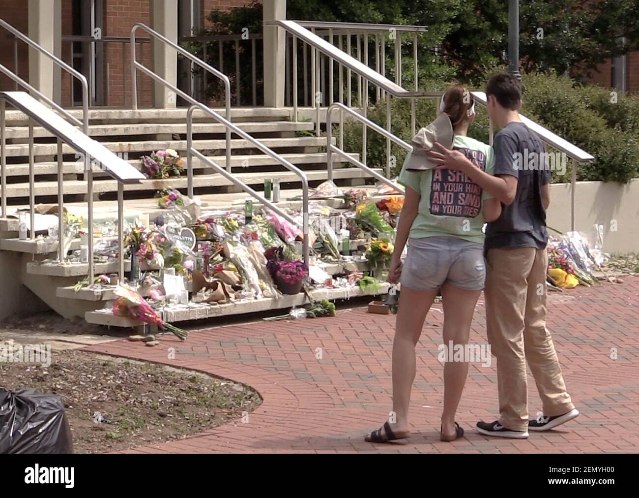 People pay respects at a memorial set up on the steps of the Kennedy ...