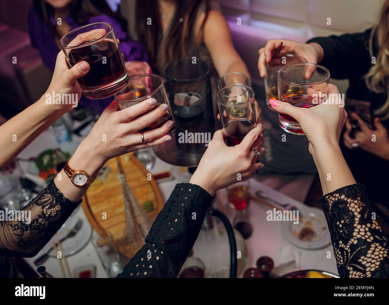 Clinking glasses with alcohol and toasting, party Stock Photo - Alamy
