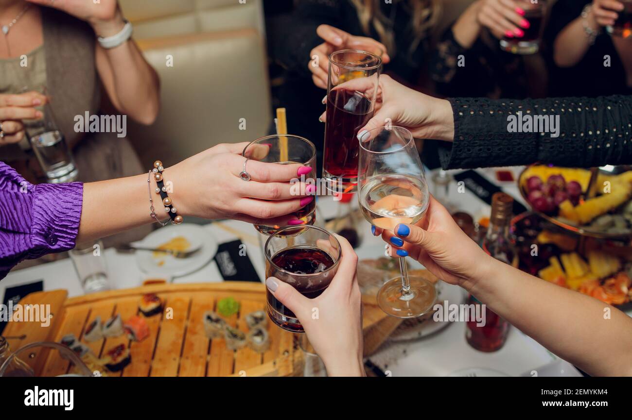 Clinking glasses with alcohol and toasting, party Stock Photo - Alamy