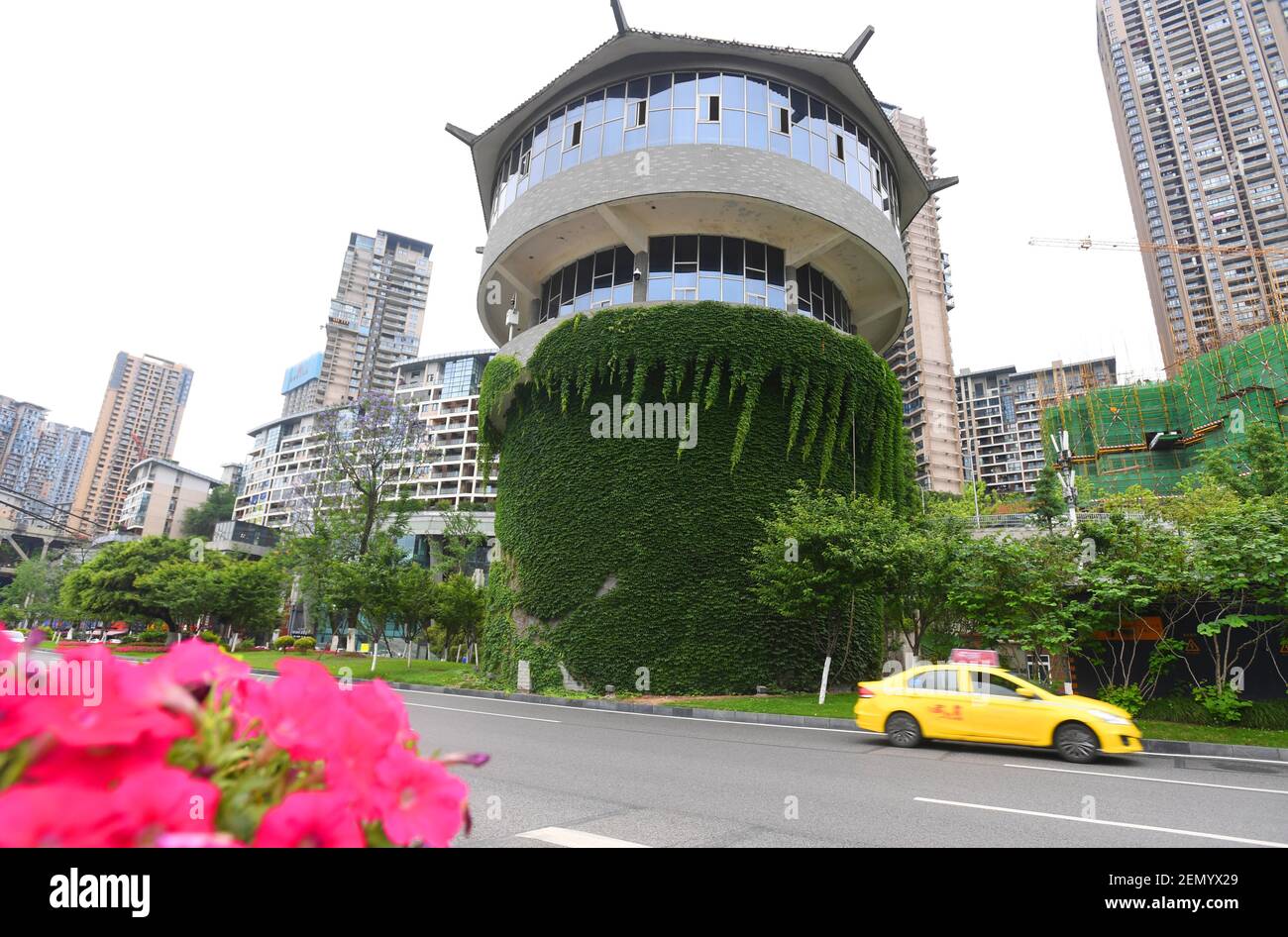 A water tower featuring the shape of hotpot is embraced by creeper ...