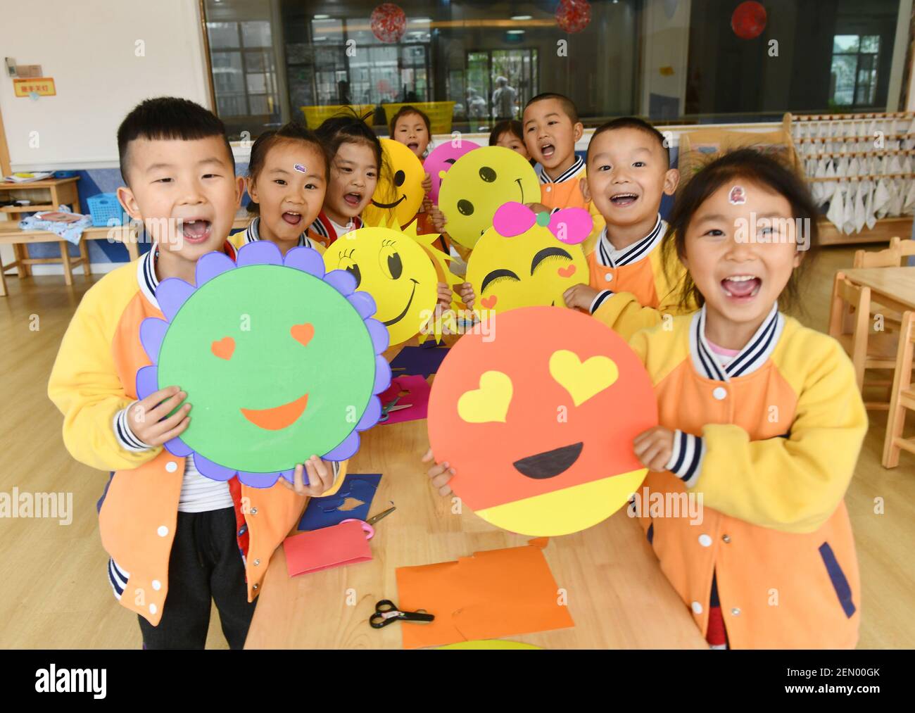 Smiley young Chinese kids show smiling cartoon faces they made to ...