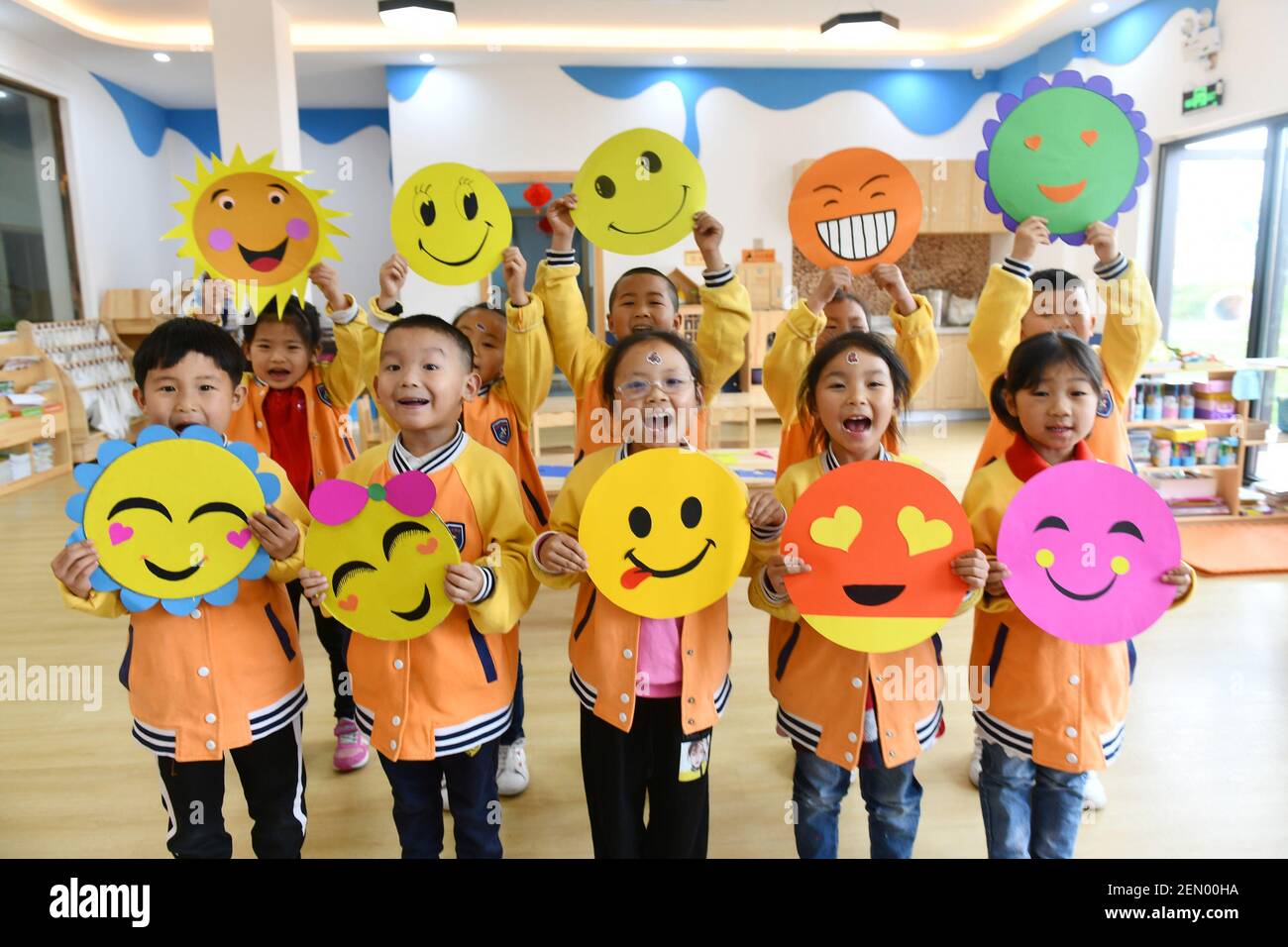 Smiley young Chinese kids show smiling cartoon faces they made to ...
