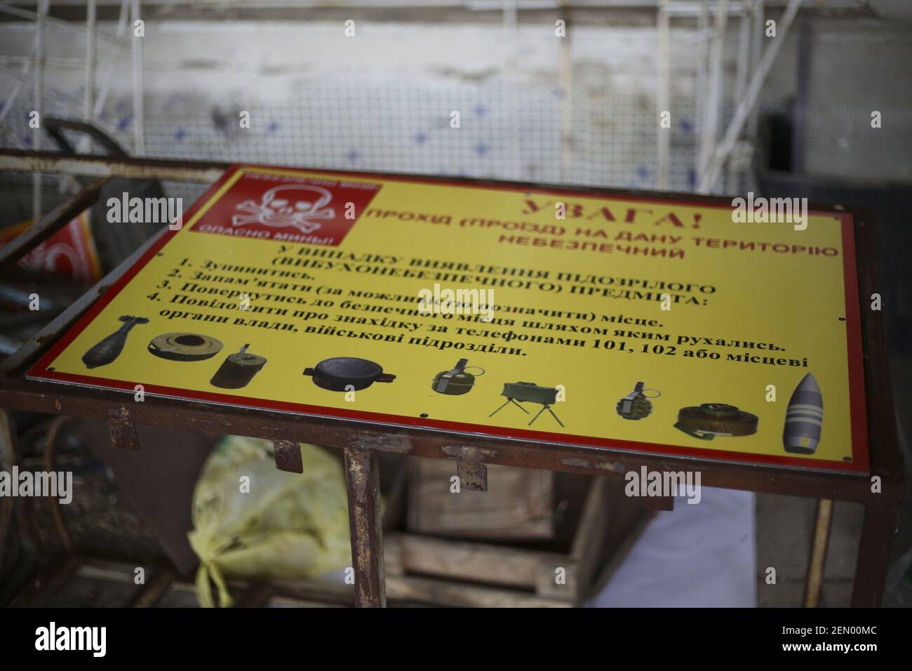A sign describing and warning of different types of land mines rests on ...