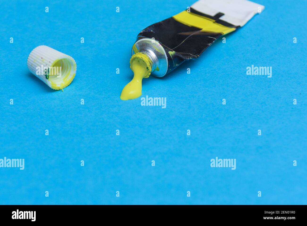 Tube of spilling yellow acrylic paint on art paper background Stock ...