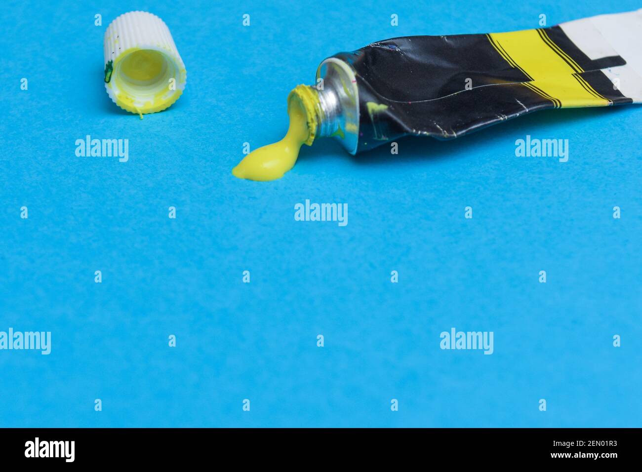 Tube of spilling yellow acrylic paint on art paper background Stock ...
