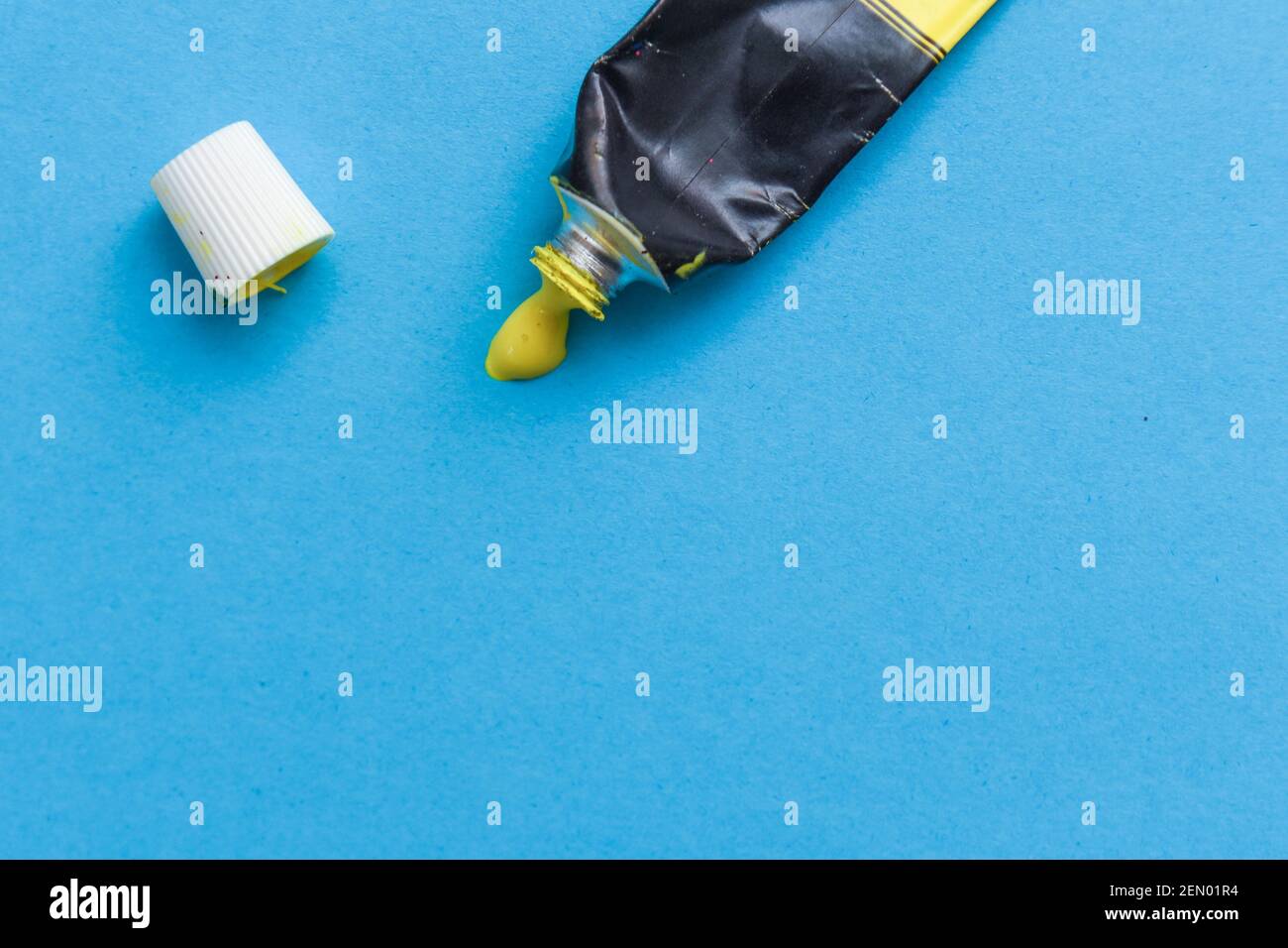 Tube of spilling yellow acrylic paint on art paper background Stock ...