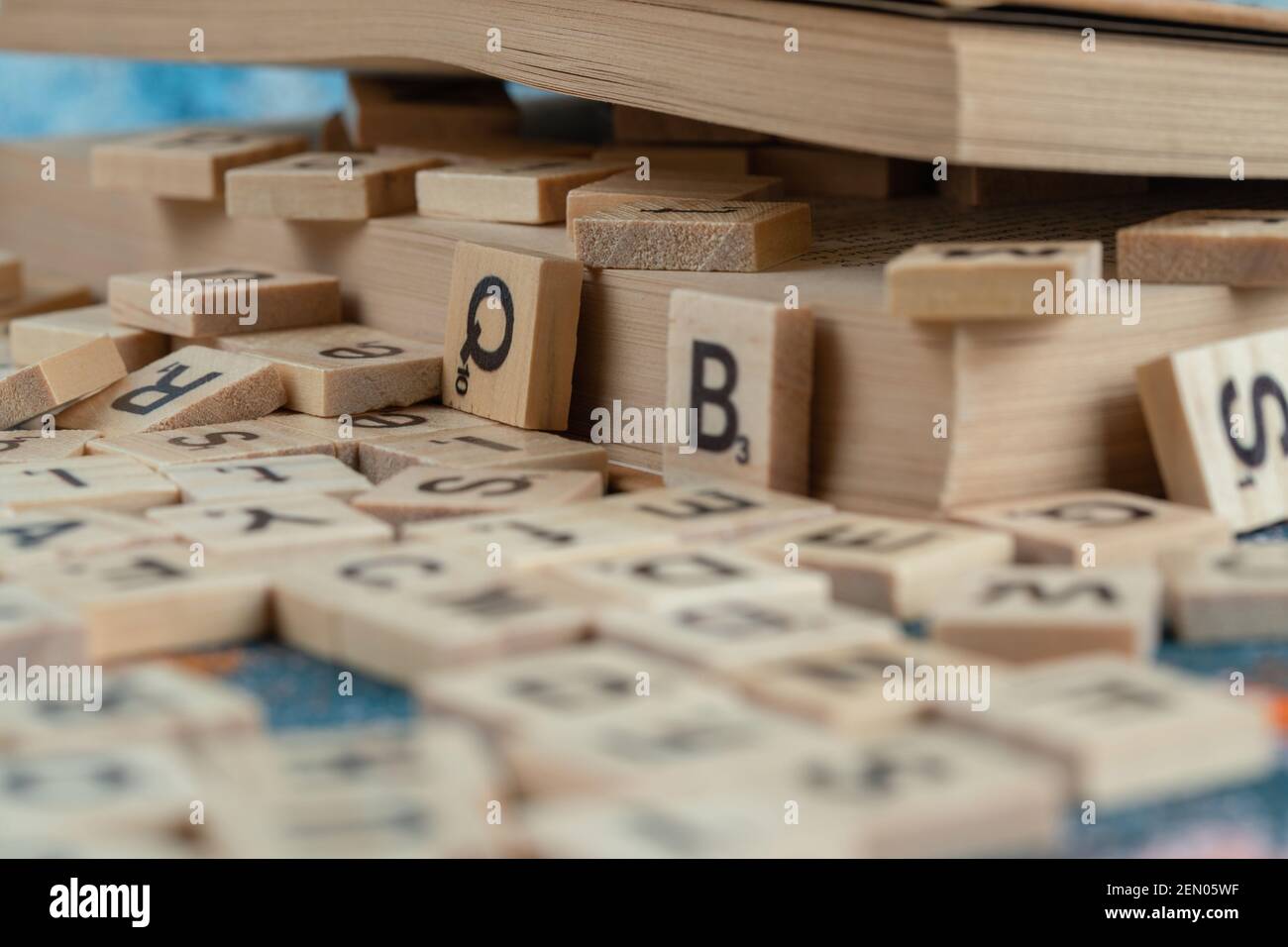 Letter dominoes made from wood and isolated on the blue pattern ...