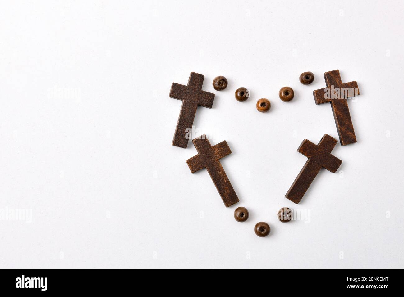 Background with heart shape made with crosses and beads on white table ...