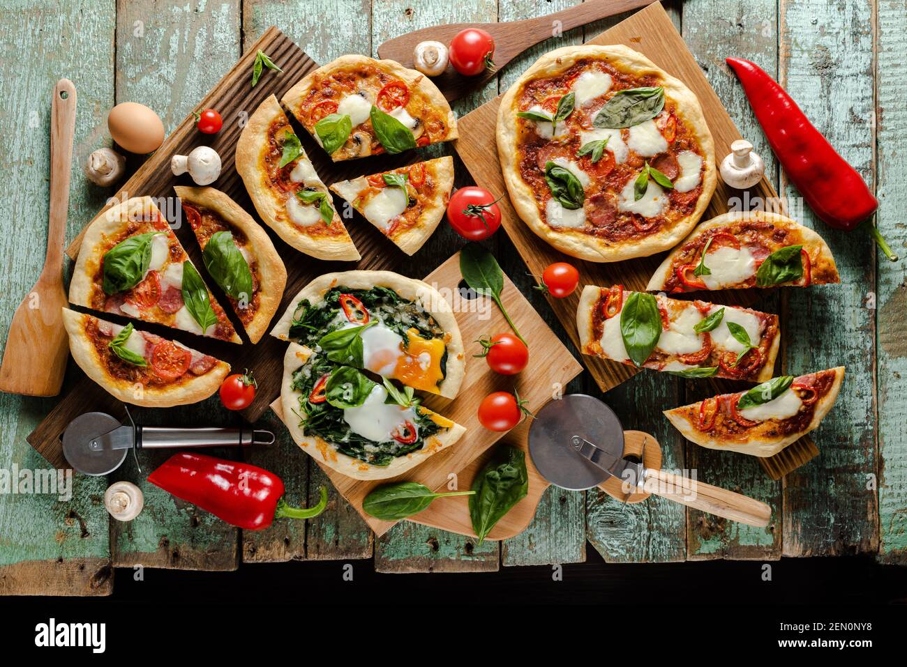 Five cutted pizzas on old painted wood overhead view Stock Photo - Alamy