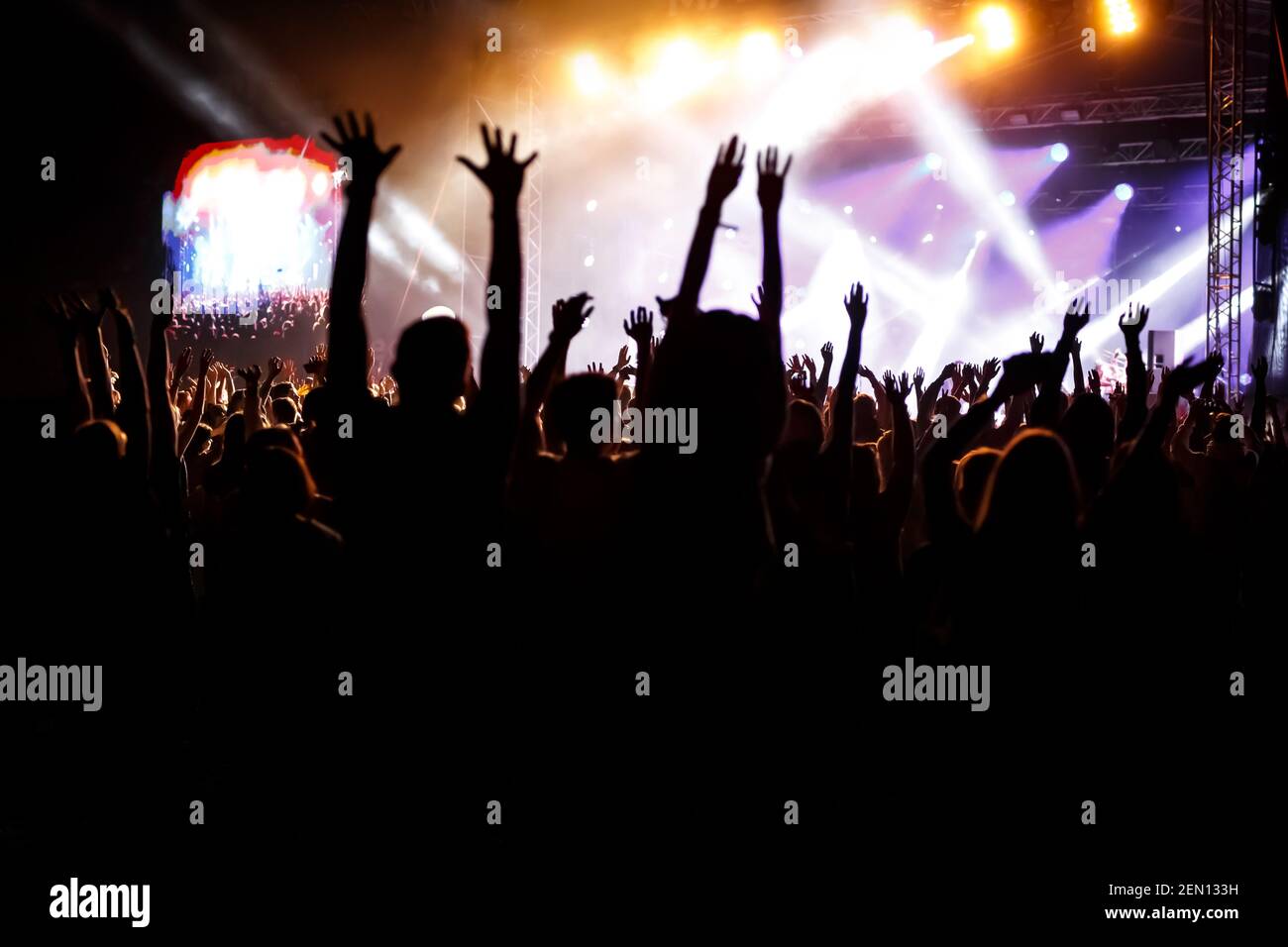 People with raised hands, silhouettes of concert crowd in front of ...